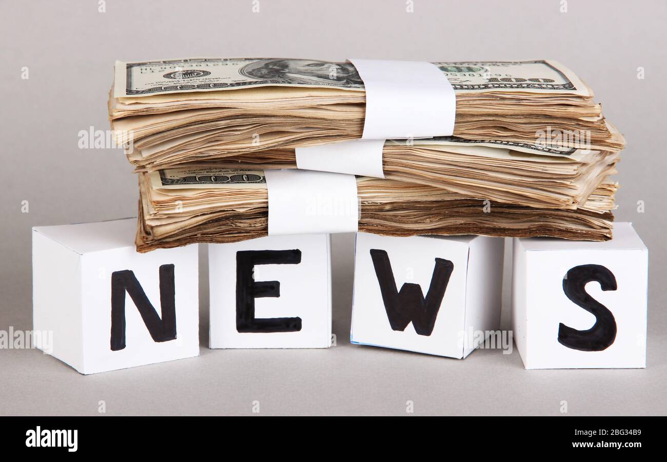 White paper cubes labeled "News" with money on grey background Stock ...