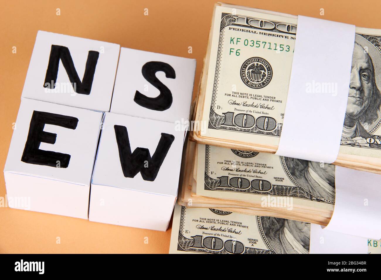 White paper cubes labeled "News" with money on beige background Stock ...