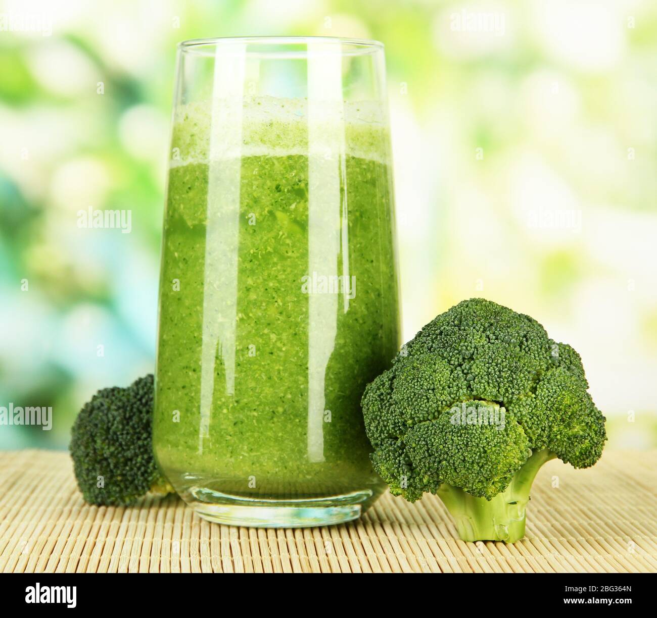 Glass of broccoli juice, on bamboo mat, on green background Stock Photo ...
