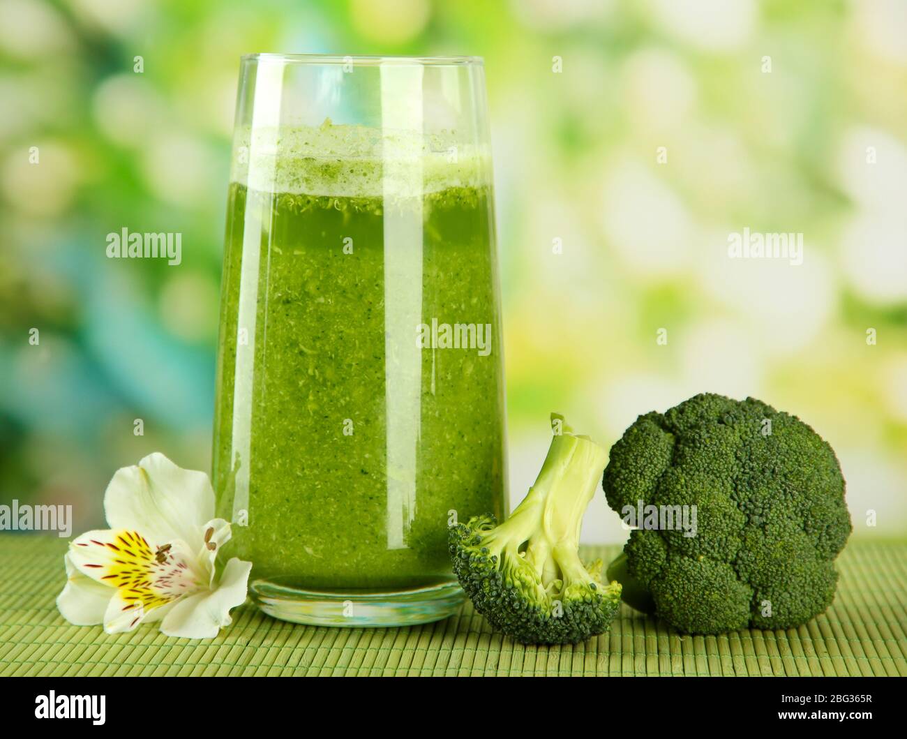 Glass of broccoli juice, on bamboo mat, on green background Stock Photo ...