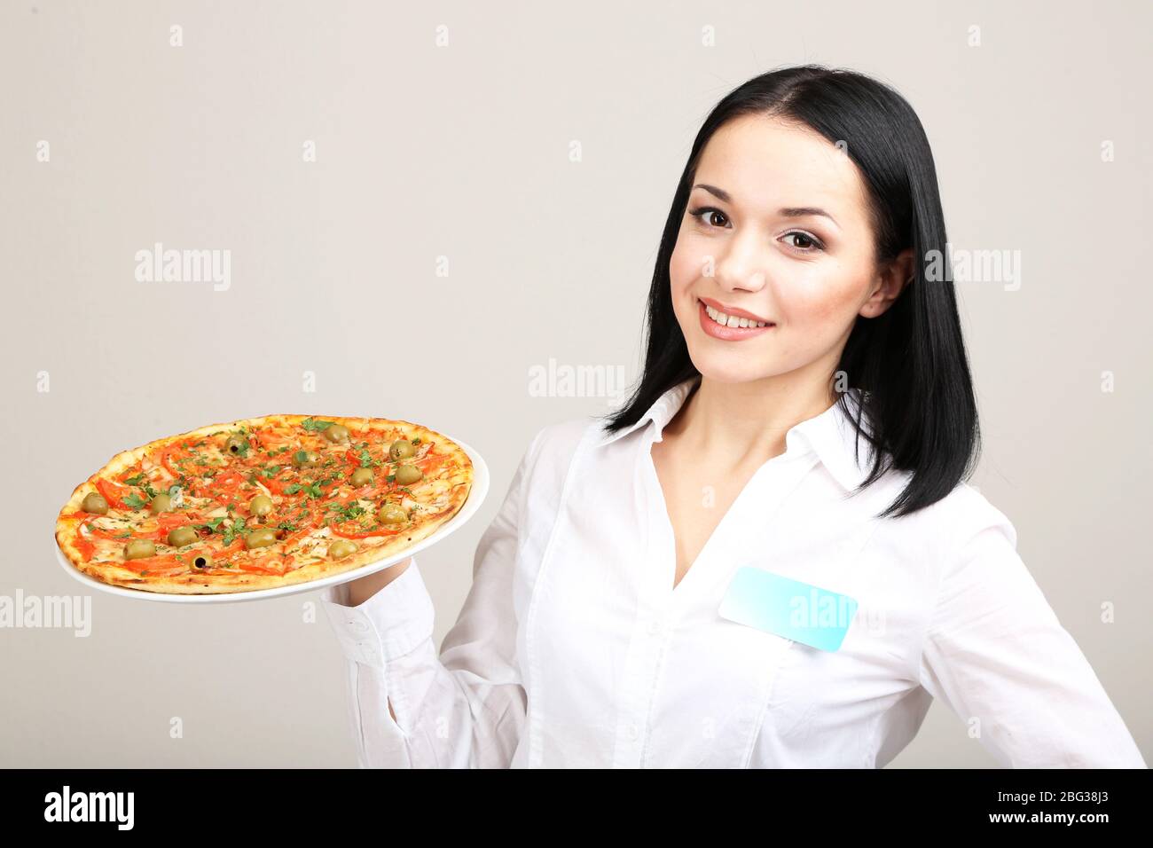 Beautiful girl waiter with pizza isolated on white Stock Photo - Alamy