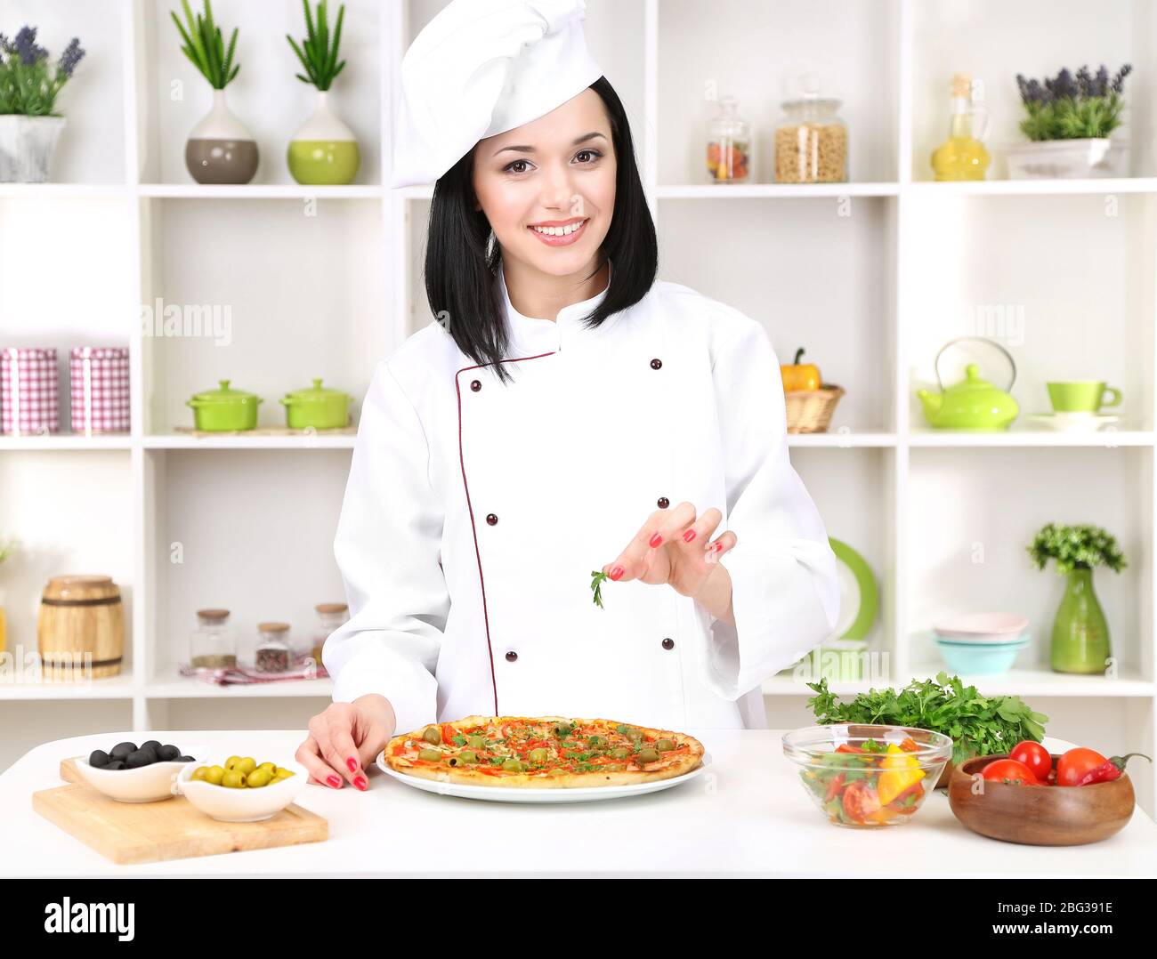 Beautiful girl chief-cooker with pizza on kitchen background Stock ...