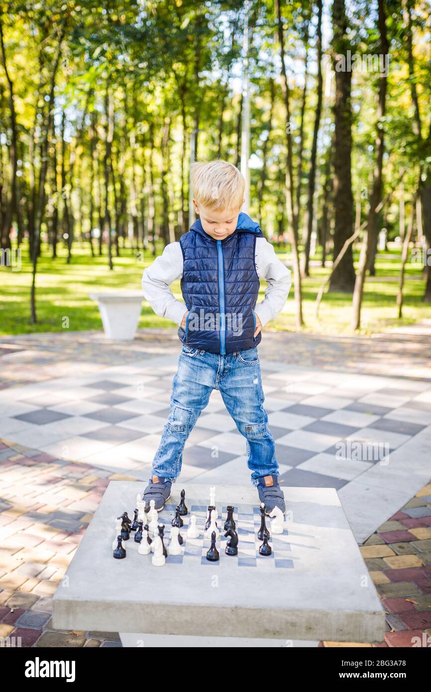 Child playing chess on board game outdoor. Hobby club children playing ...