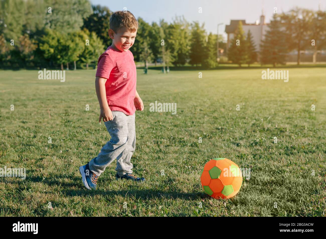 Caucasian boy playing soccer football on playground outside. Preschool ...