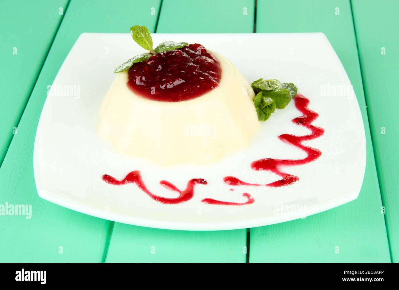 Panna Cotta with raspberry sauce, on color wooden background Stock ...