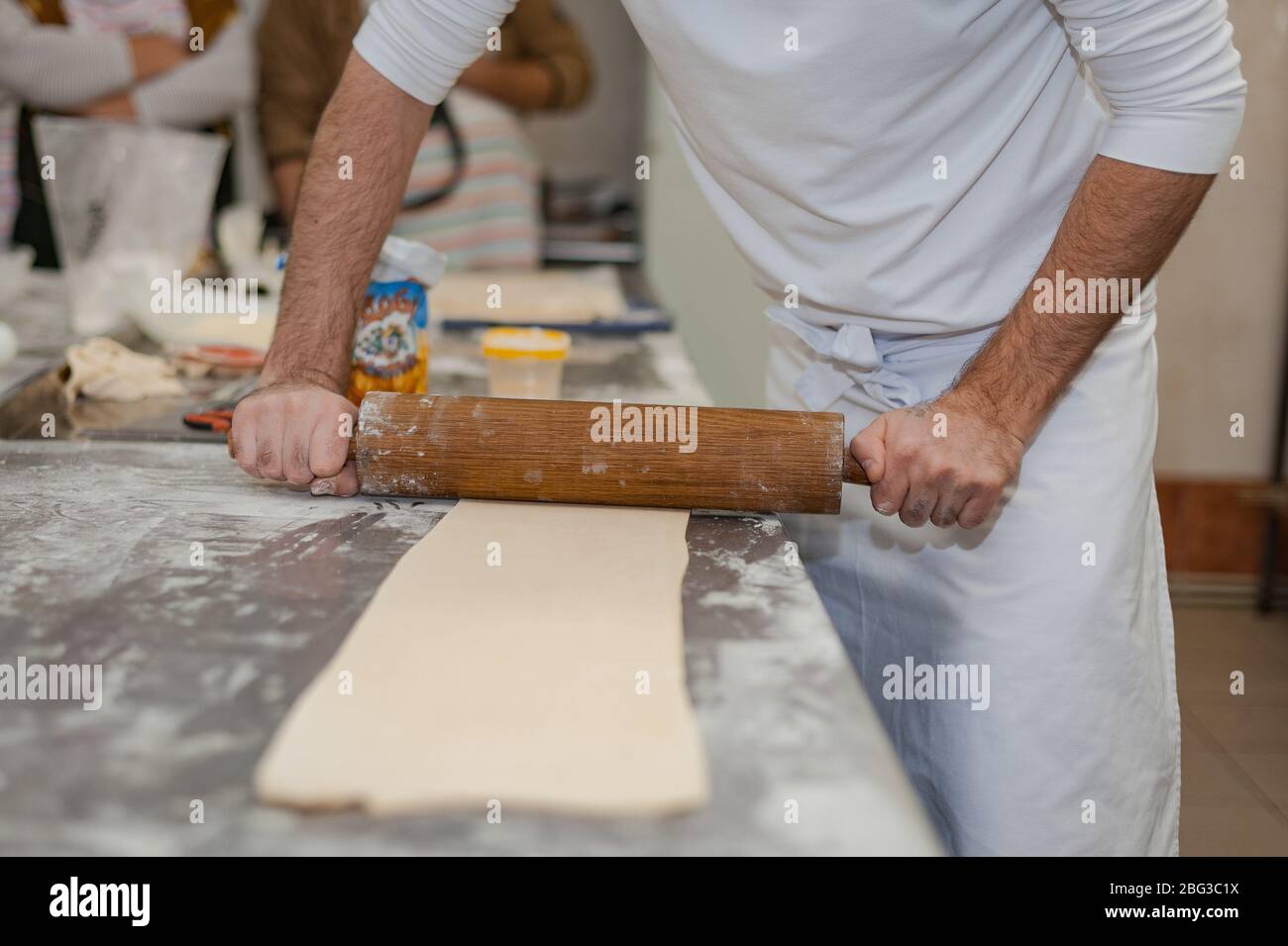 The process of preparing puff pastry in a bakery. The baker rolls the ...