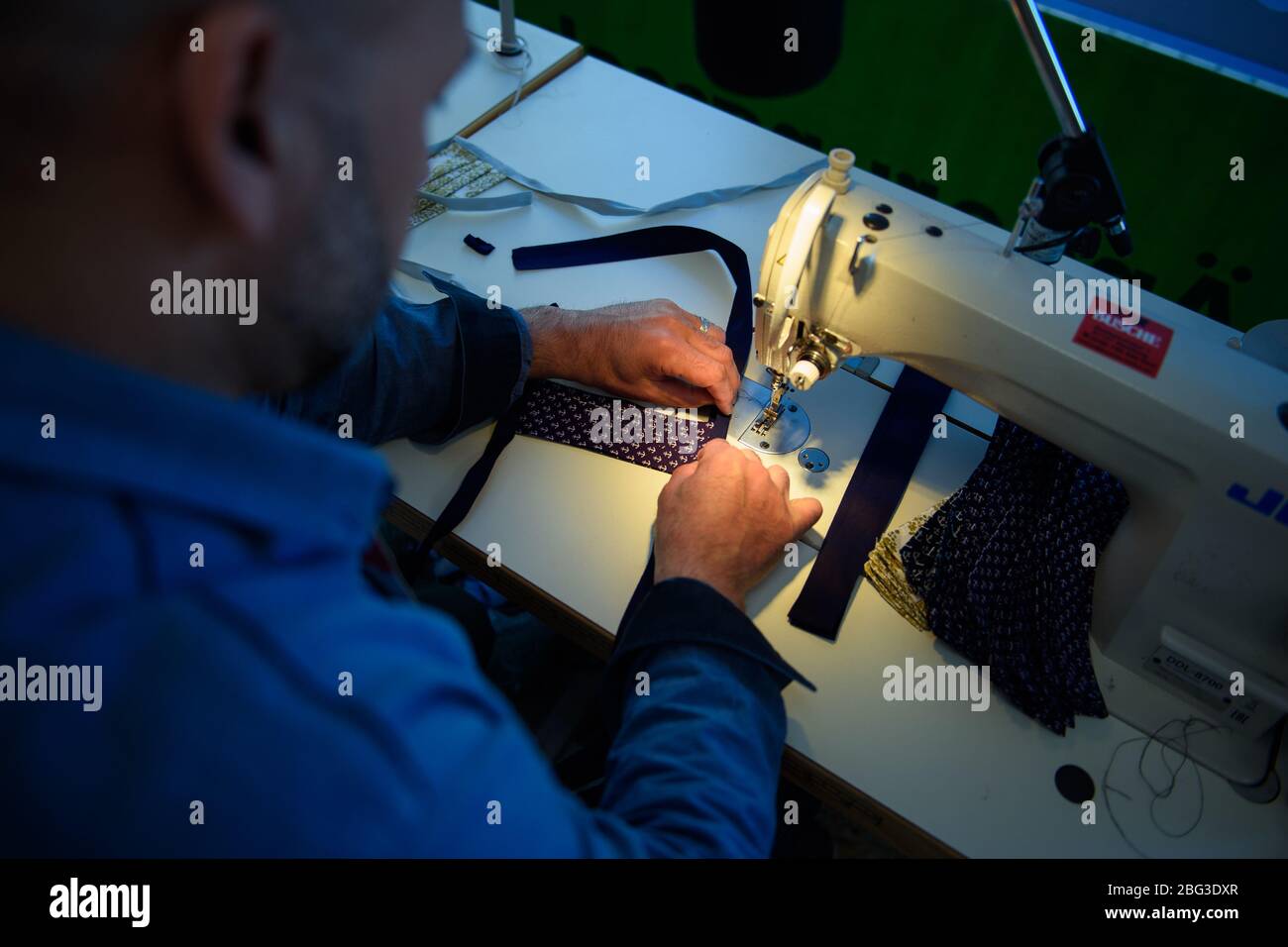 Kiel, Germany. 20th Apr, 2020. An employee of an alteration tailor shop ...
