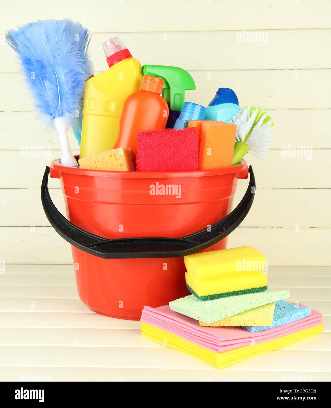 Cleaning items in bucket on white wooden background Stock Photo - Alamy