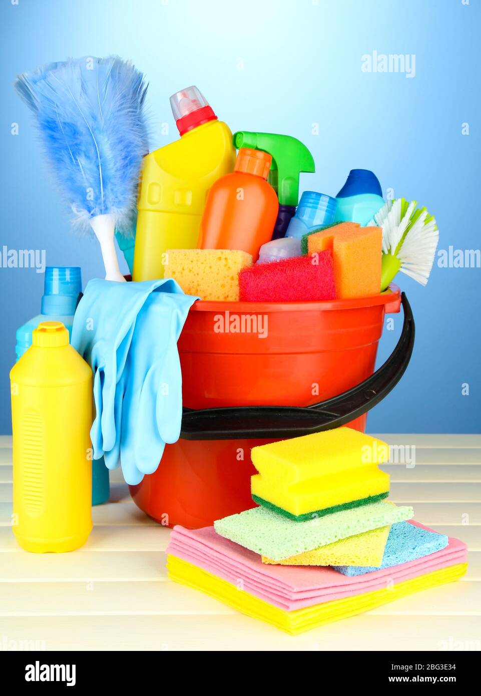Cleaning items in bucket on color background Stock Photo - Alamy