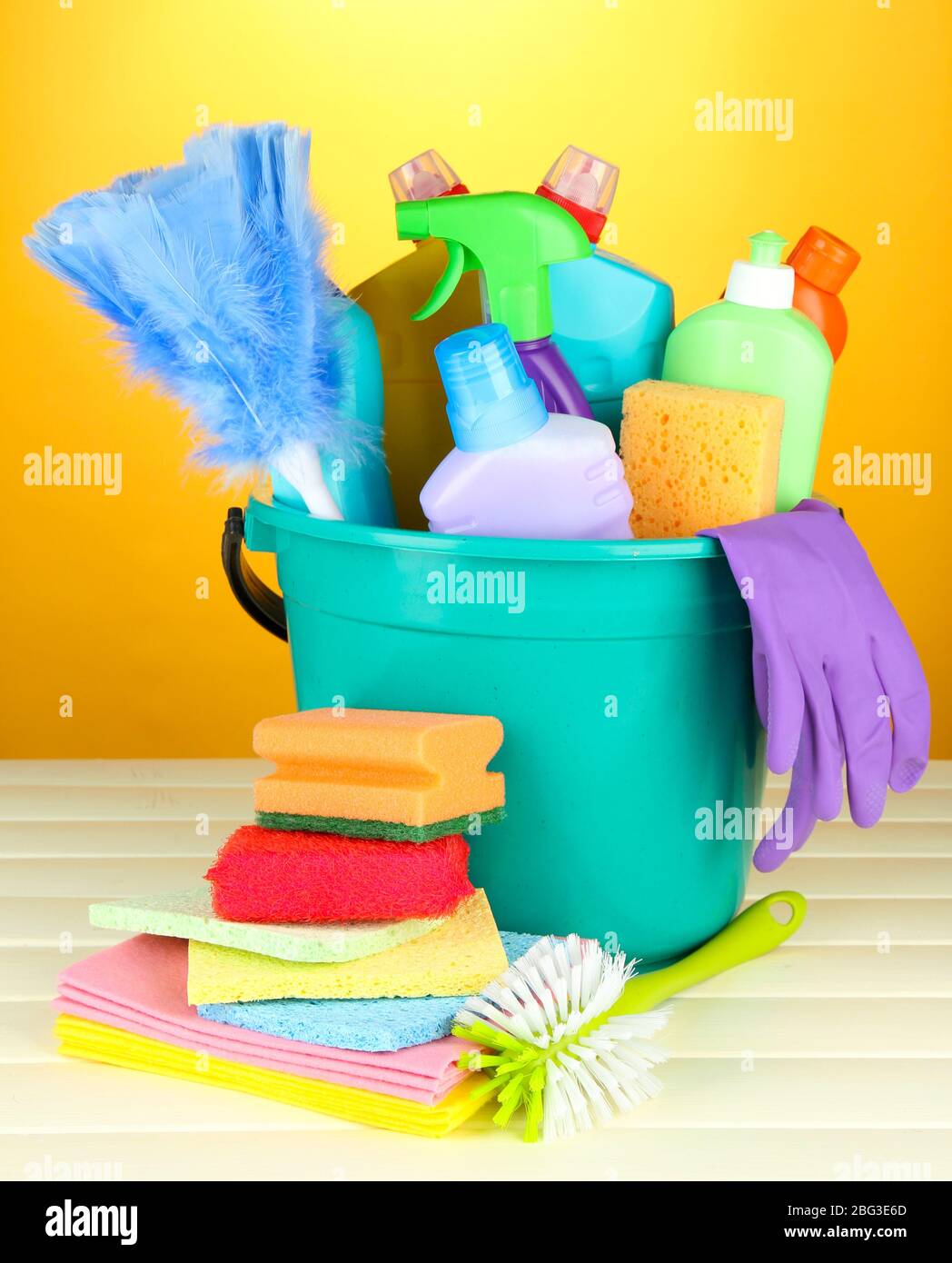 Cleaning items in bucket on color background Stock Photo - Alamy