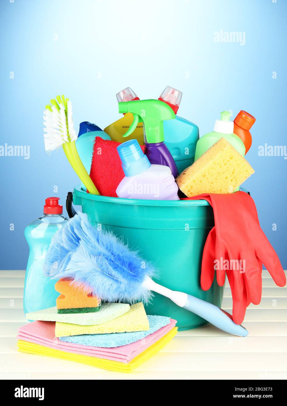 Cleaning items in bucket on color background Stock Photo - Alamy