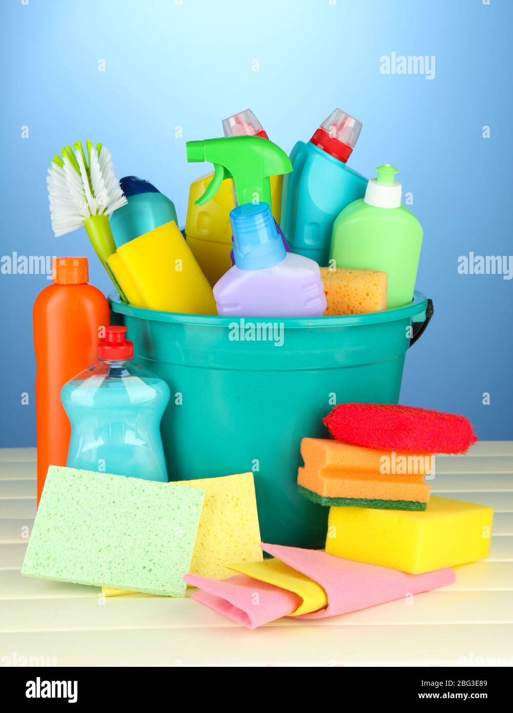 Cleaning items in bucket on color background Stock Photo - Alamy