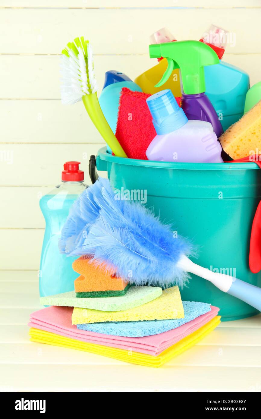 Cleaning items in bucket on white wooden background Stock Photo - Alamy