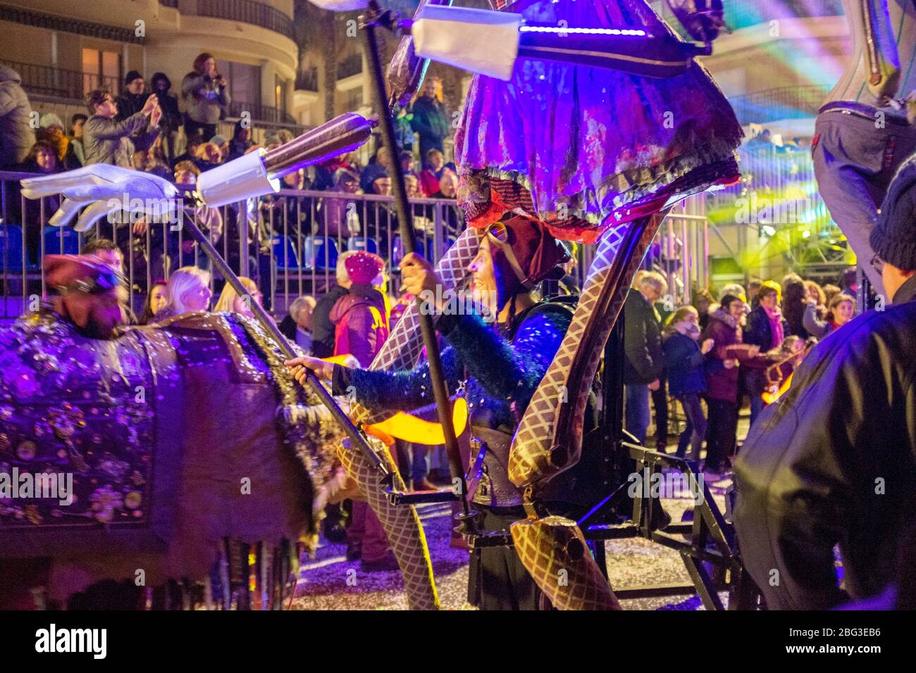Smiling puppeteer controls a demon puppet in the night parade of the ...