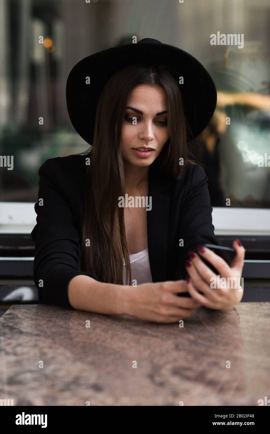 A woman sitting down talking on a cell phone Stock Photo - Alamy