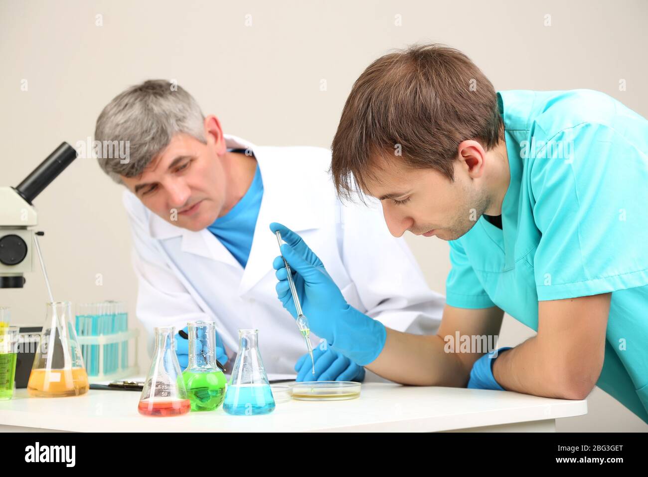 Physician and assayer during research on room background Stock Photo ...