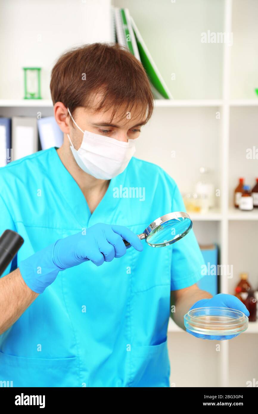Assayer during research on laboratory background Stock Photo - Alamy