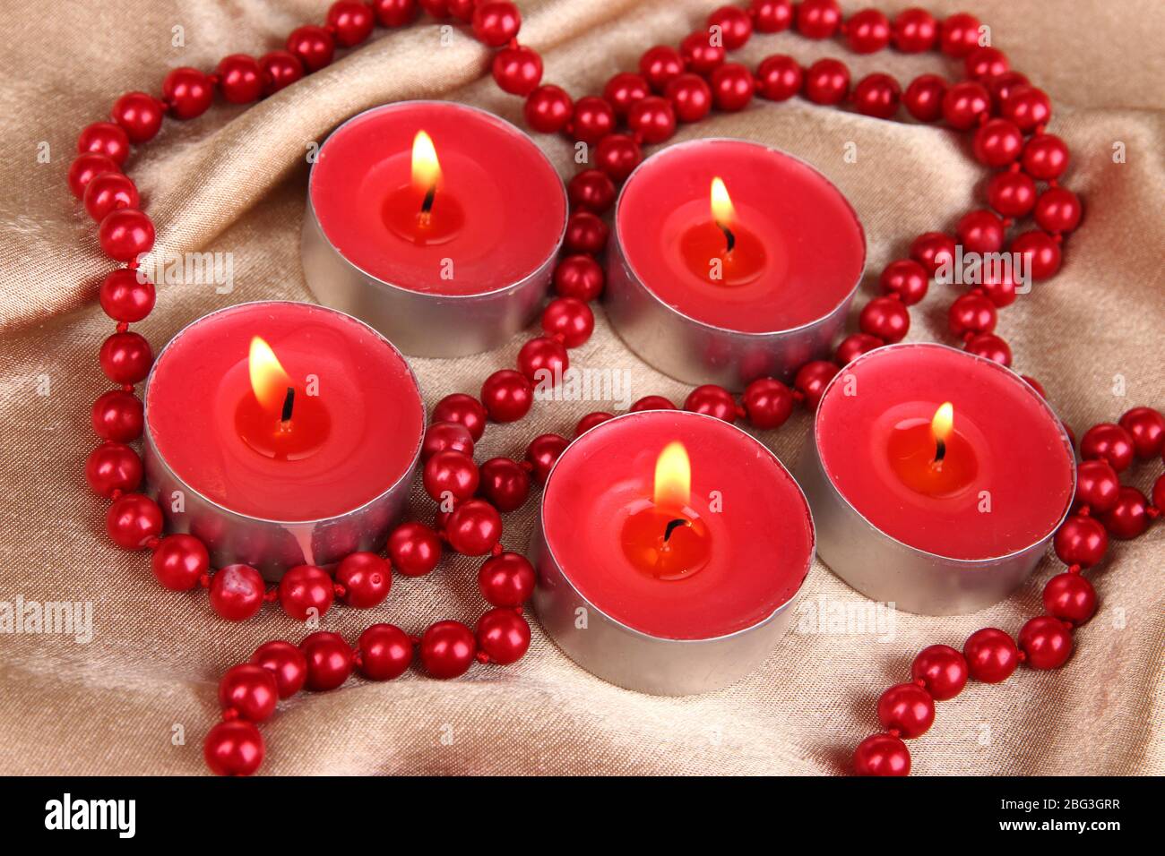 Candles on golden fabric close-up Stock Photo - Alamy