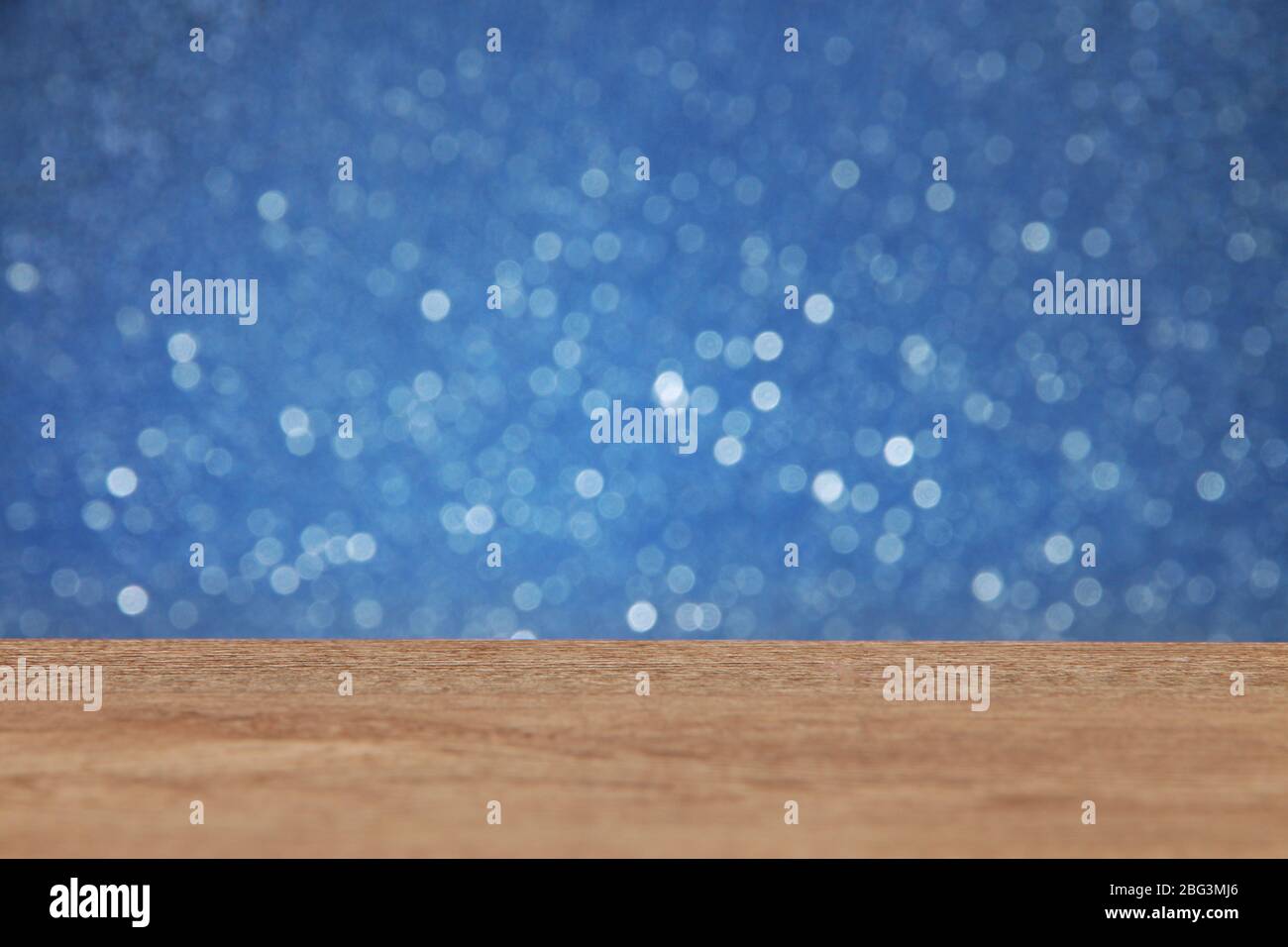 Wooden table on blue background Stock Photo - Alamy