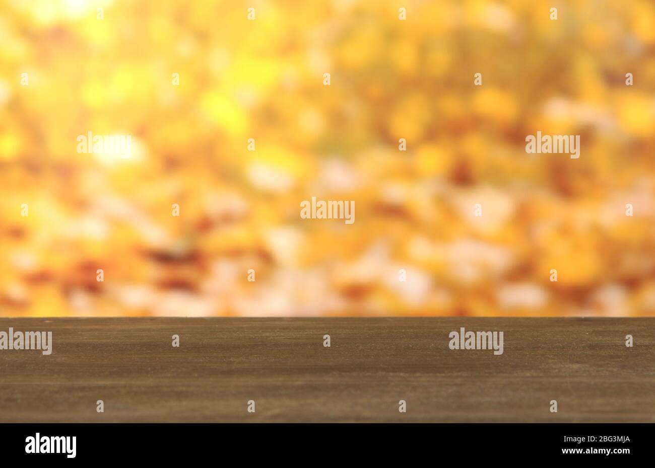 Wooden table on bright yellow background Stock Photo - Alamy