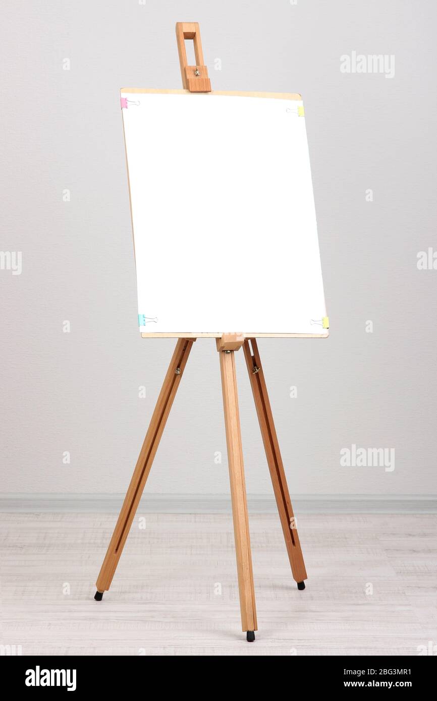 Wooden easel with clean paper in room Stock Photo - Alamy