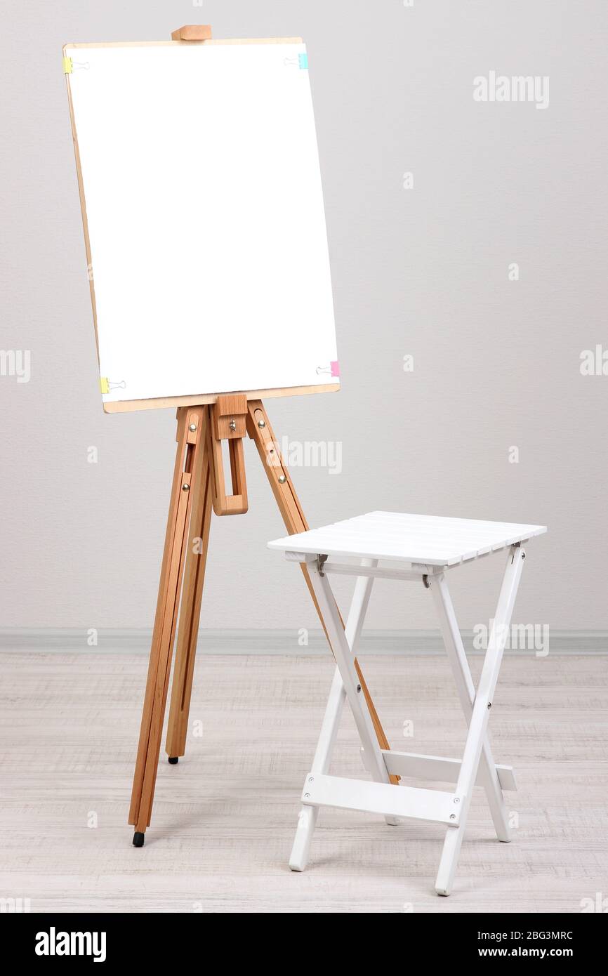 Wooden easel with clean paper in room Stock Photo - Alamy
