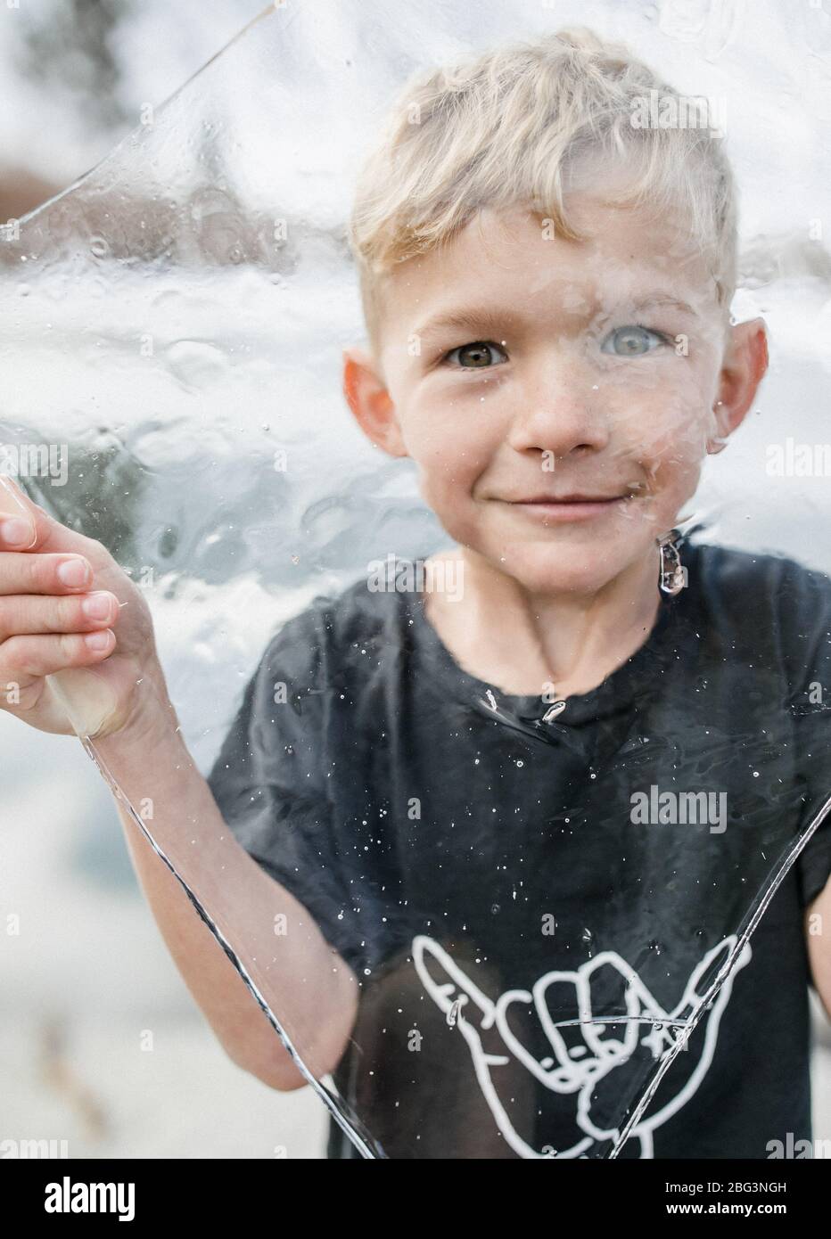 Portrait of a smiling boy looking through a sheet of ice Stock Photo ...