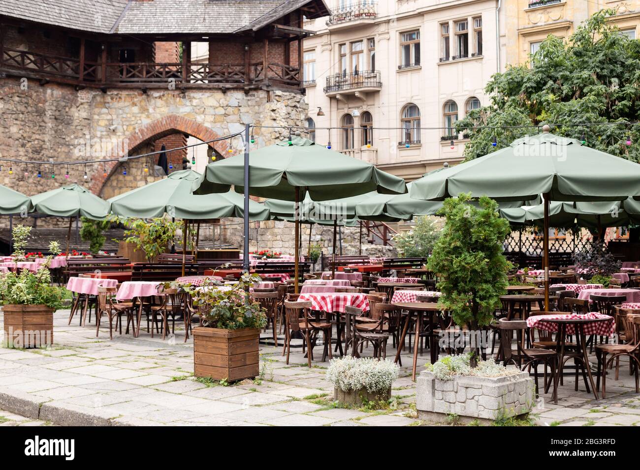 Empty cafe near ancient buildings and castle. A lot of empty tables in ...