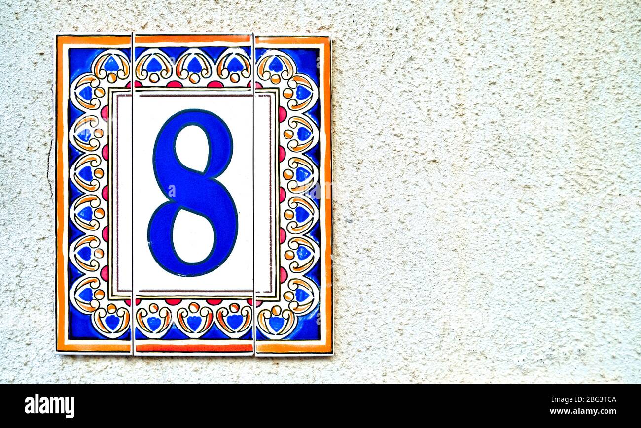 Eight (8) number on a tile on a wall, offset, empty text space on one ...