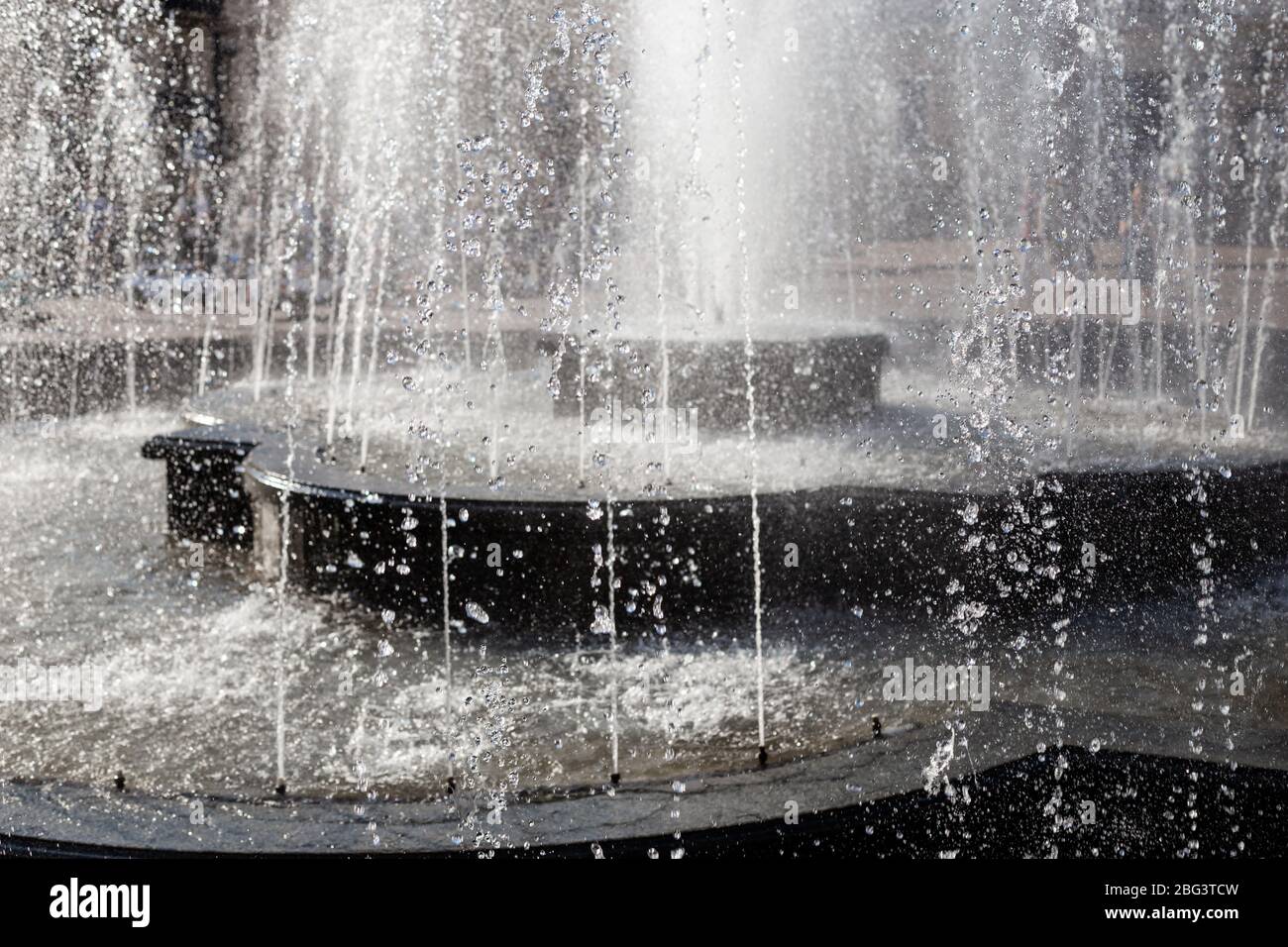 Splash and drops in a spring fontain. Water falling, close up shot ...
