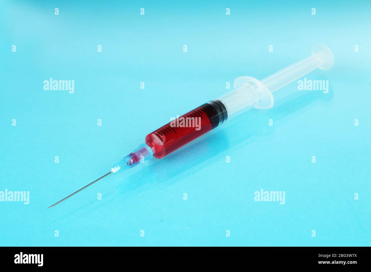 Plastic disposable syringe filled with blood on blue background Stock ...