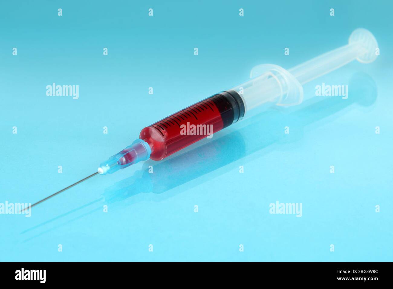Plastic disposable syringe filled with blood on blue background Stock ...