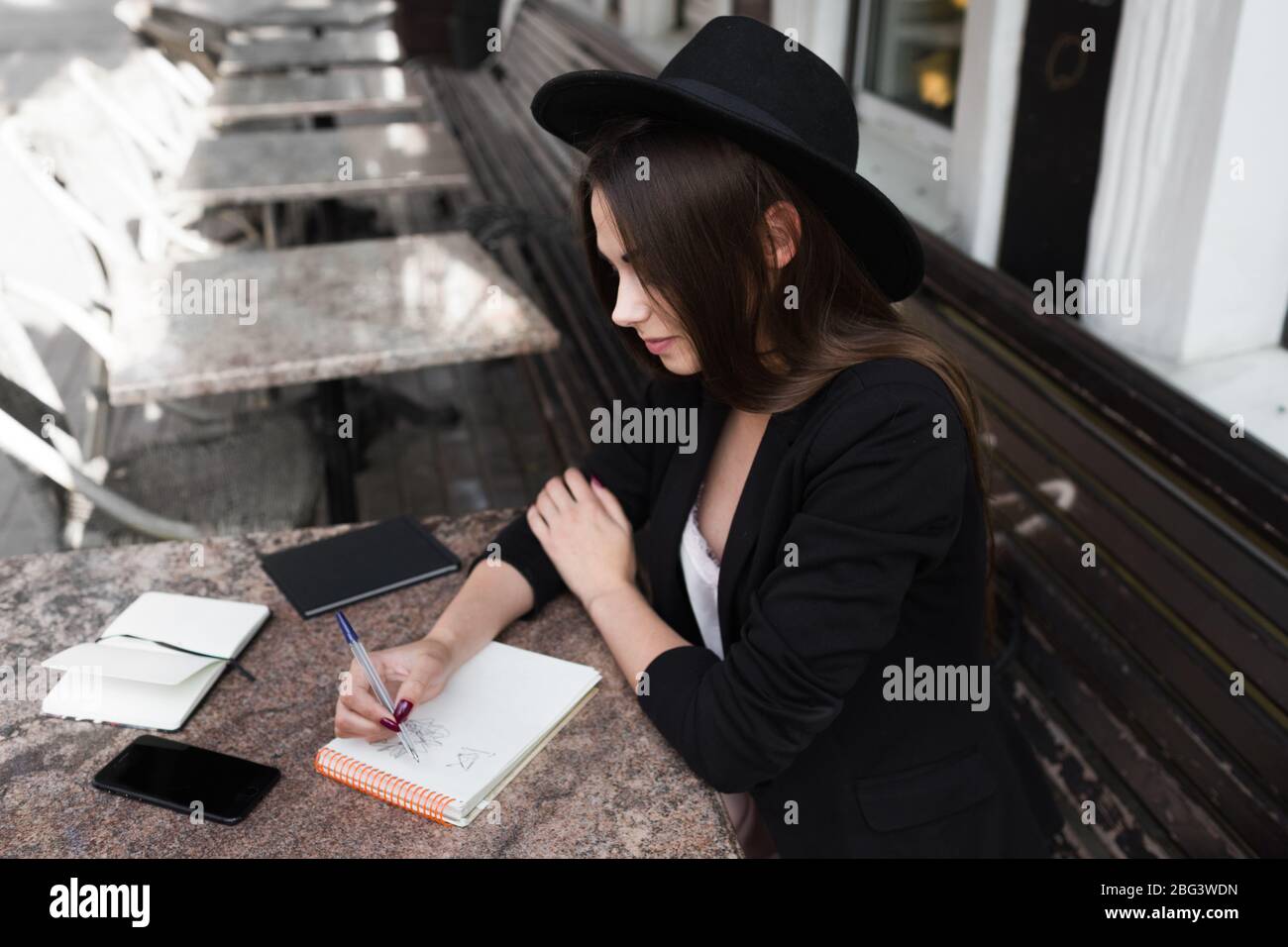 A young girl writer writes articles for a fashion magazine on a summer ...