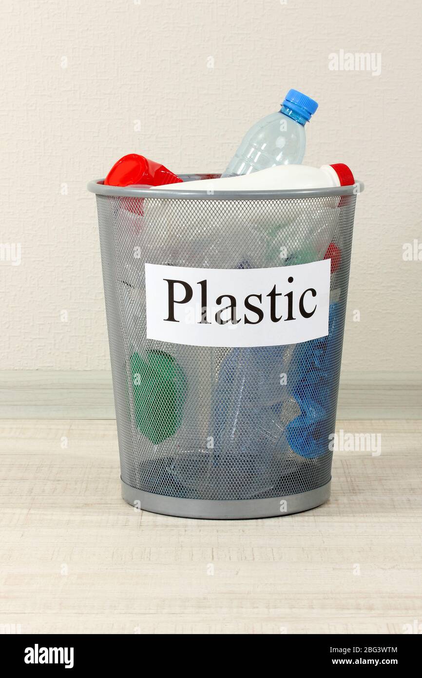 Assorted trash in bucket on room background Stock Photo - Alamy