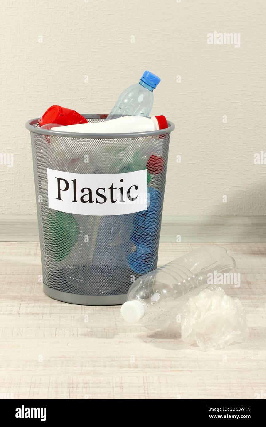 Assorted trash in bucket on room background Stock Photo - Alamy
