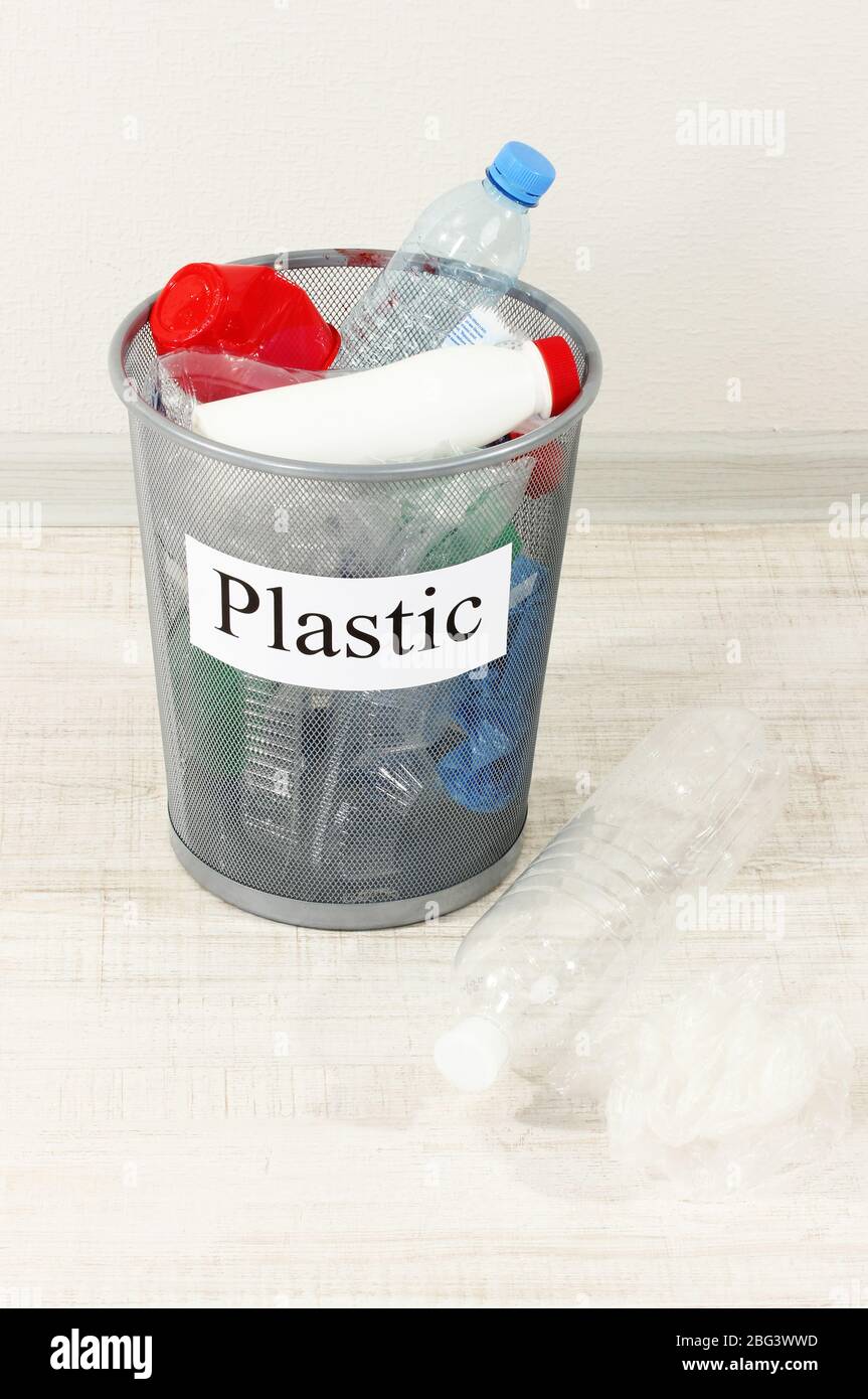 Assorted trash in bucket on room background Stock Photo - Alamy