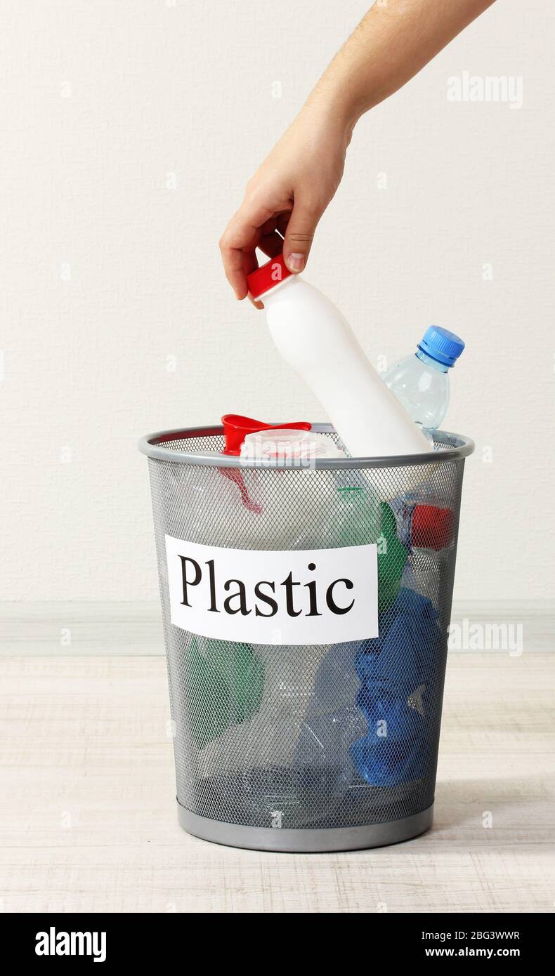 Assorted trash in bucket on room background Stock Photo - Alamy