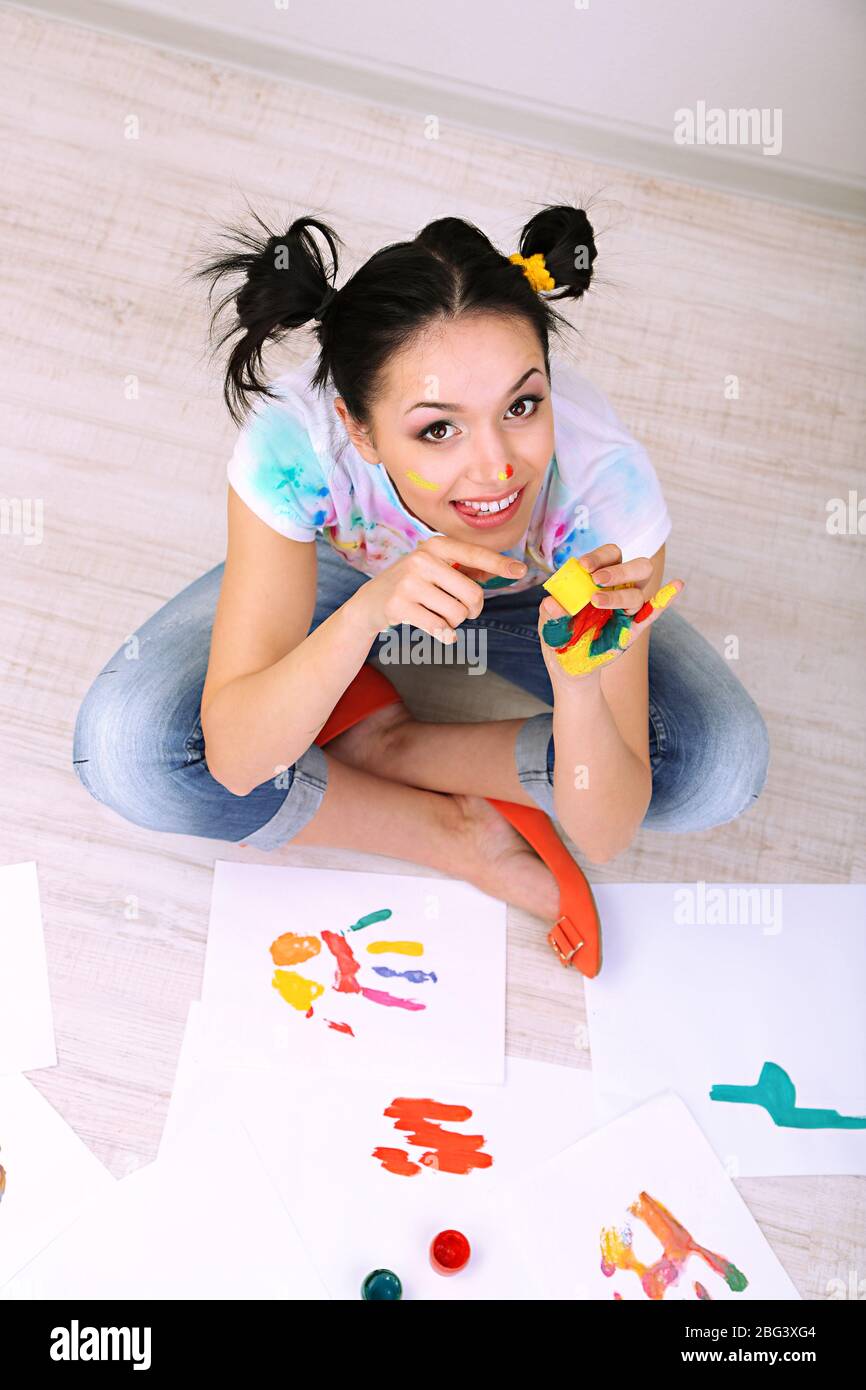 Young pretty painter with hands in paint, on gray background Stock Photo - Alamy