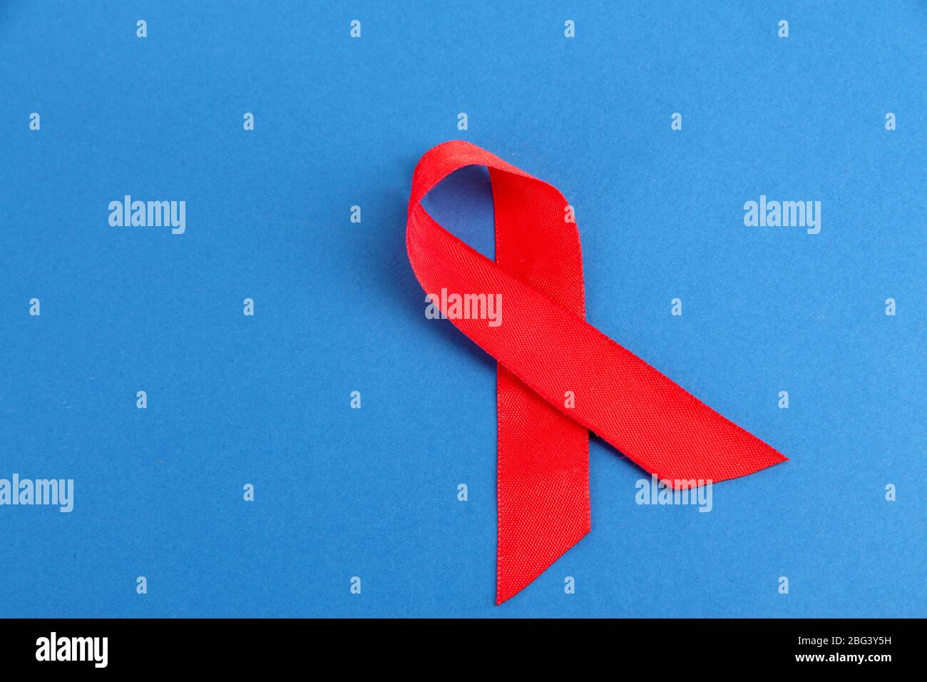 Red ribbon HIV, AIDS on blue background Stock Photo - Alamy
