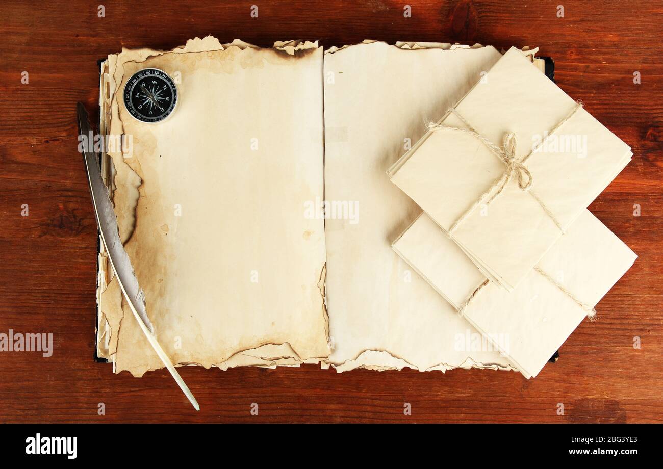 Open old book, letters and compass on wooden background Stock Photo - Alamy