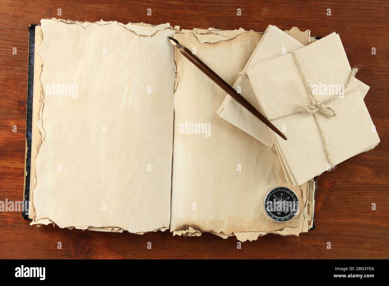 Open old book, letters and compass on wooden background Stock Photo - Alamy
