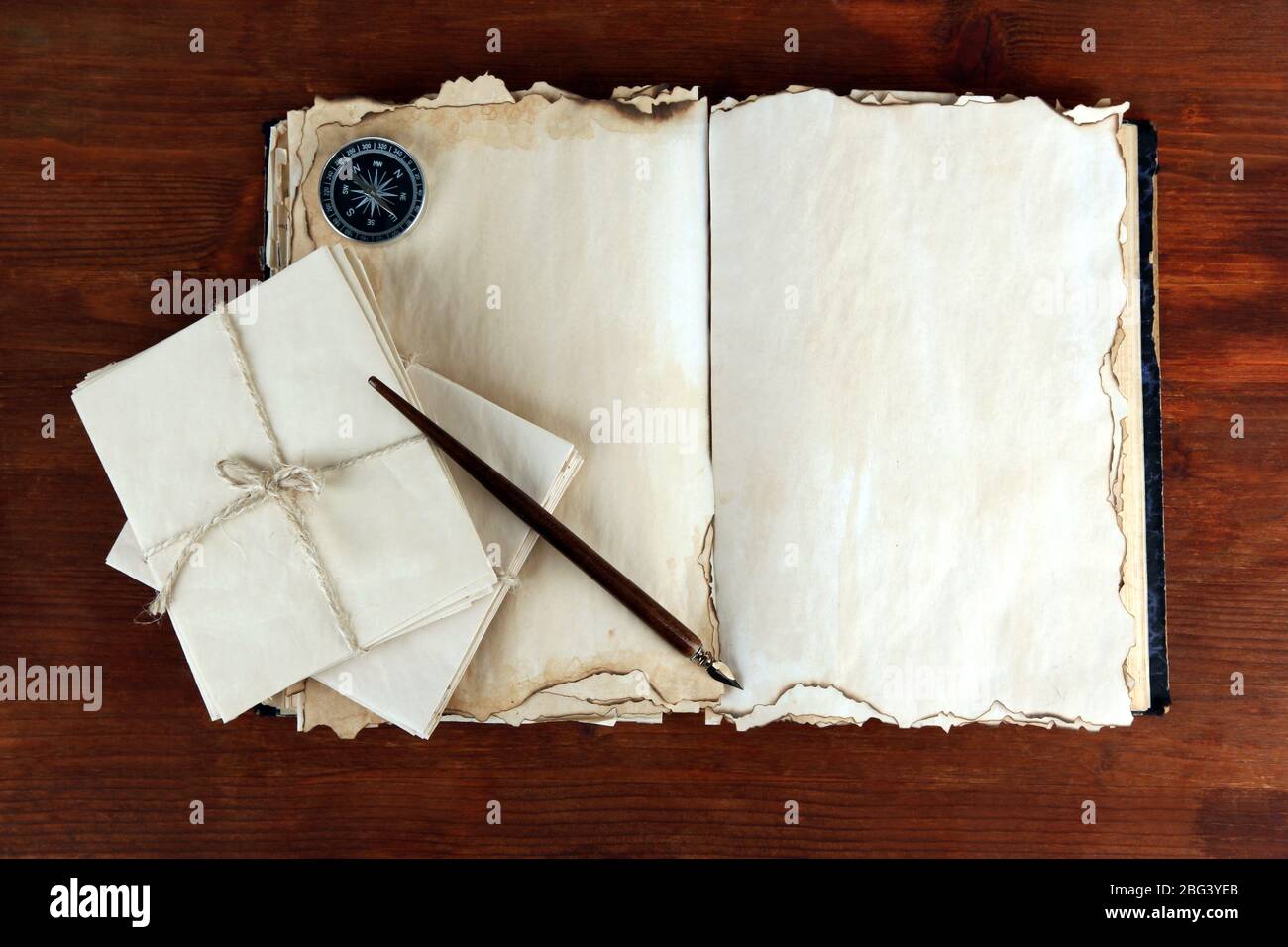 Open old book, letters and compass on wooden background Stock Photo - Alamy