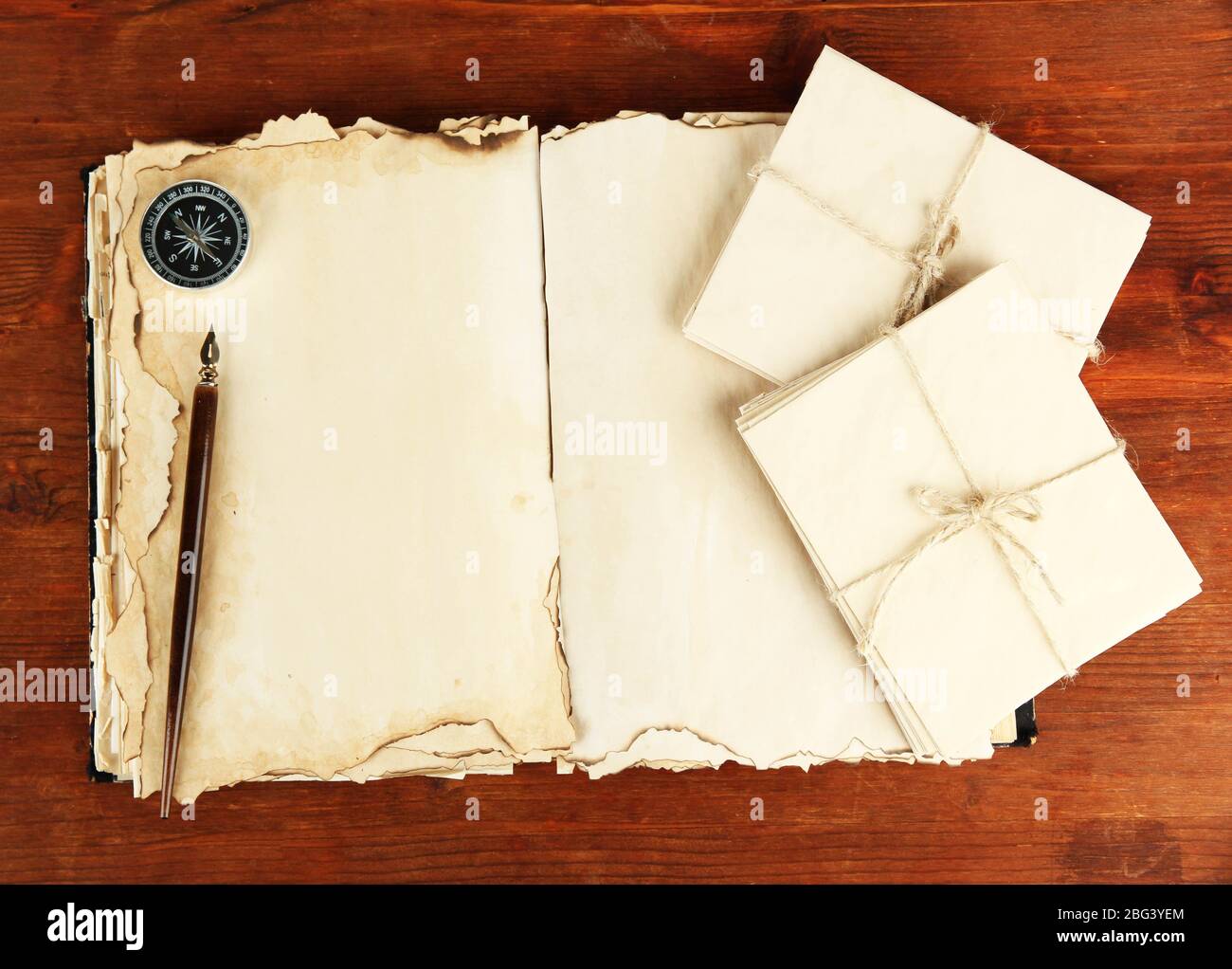 Open old book, letters and compass on wooden background Stock Photo - Alamy