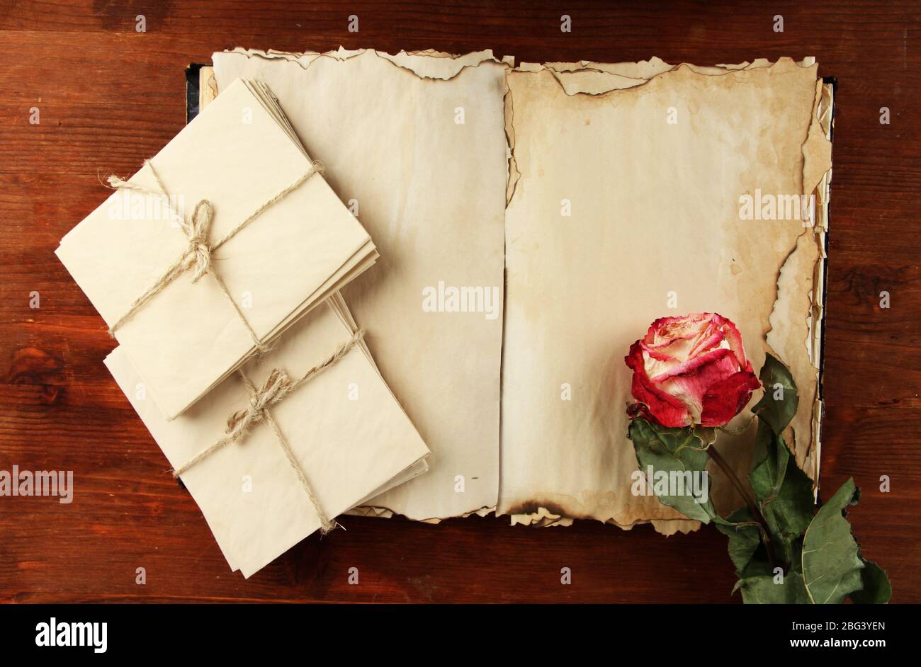 Open old book, letters and rose on wooden background Stock Photo - Alamy