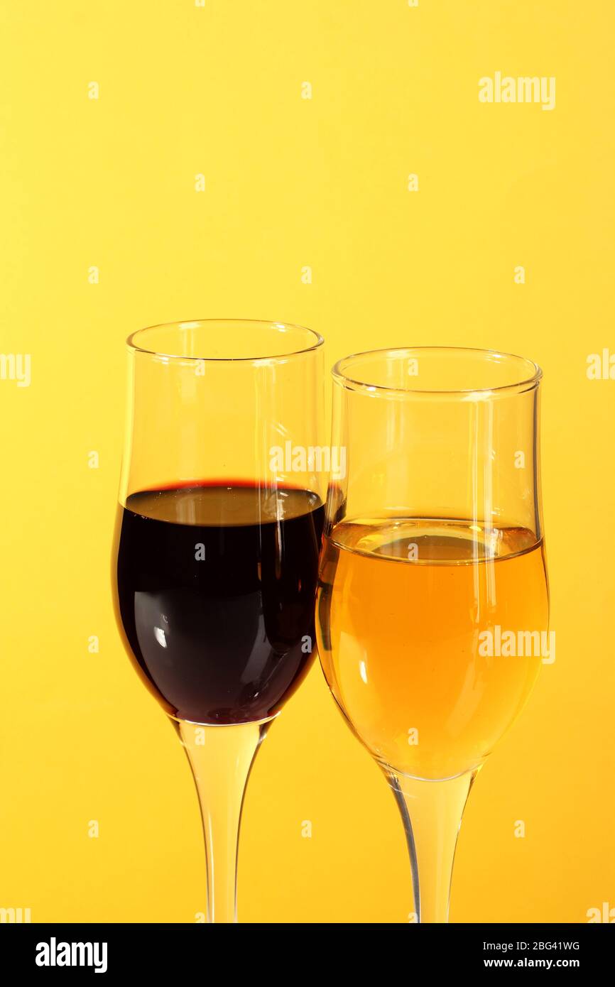 Wine in glasses on yellow background Stock Photo - Alamy