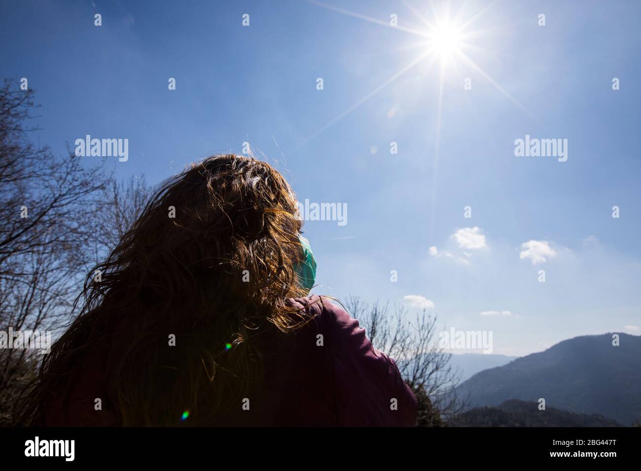 Rear view of a woman standing outdoors wearing a face mask, Spain Stock ...