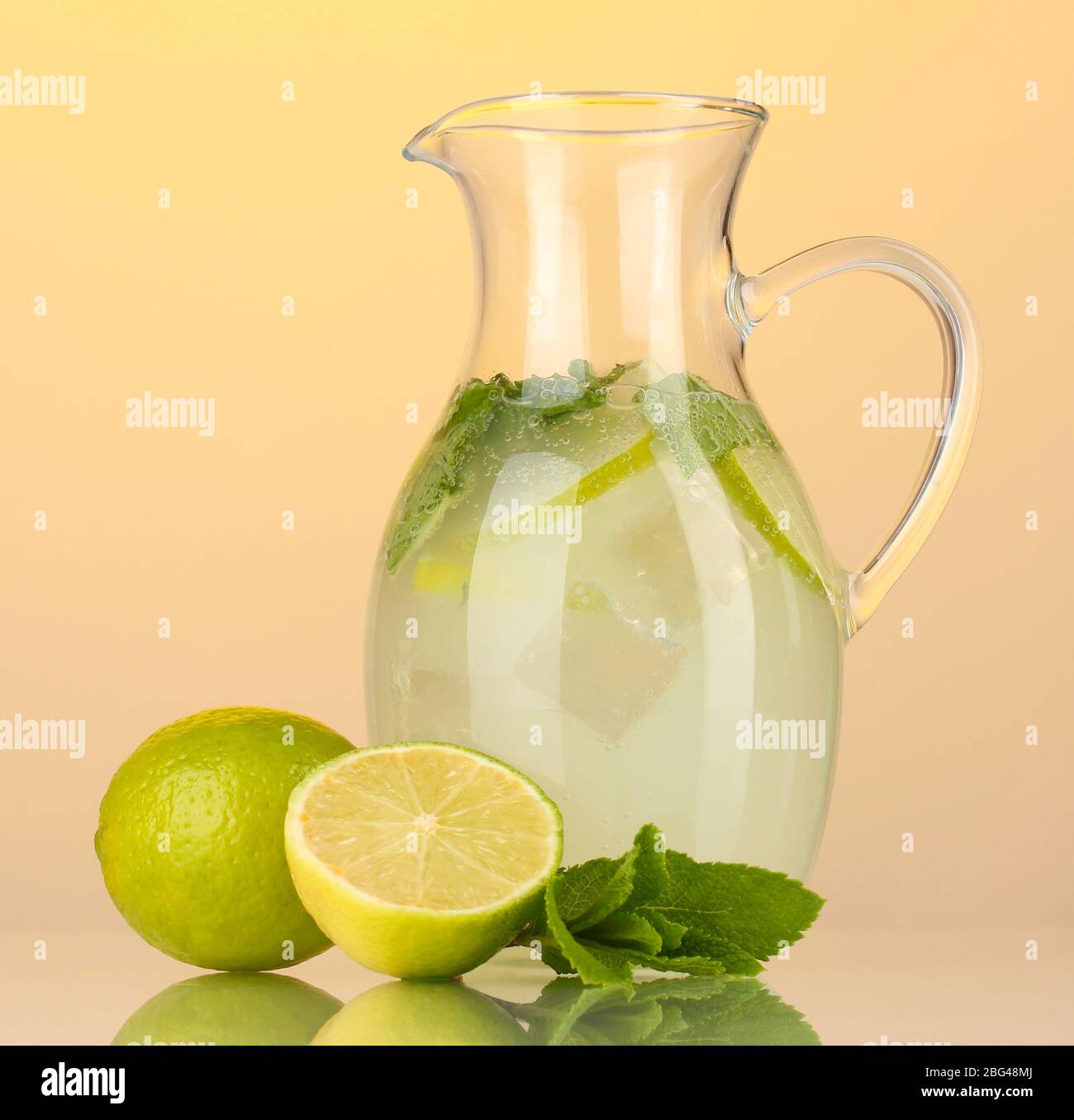 Lemonade in pitcher on yellow background Stock Photo - Alamy