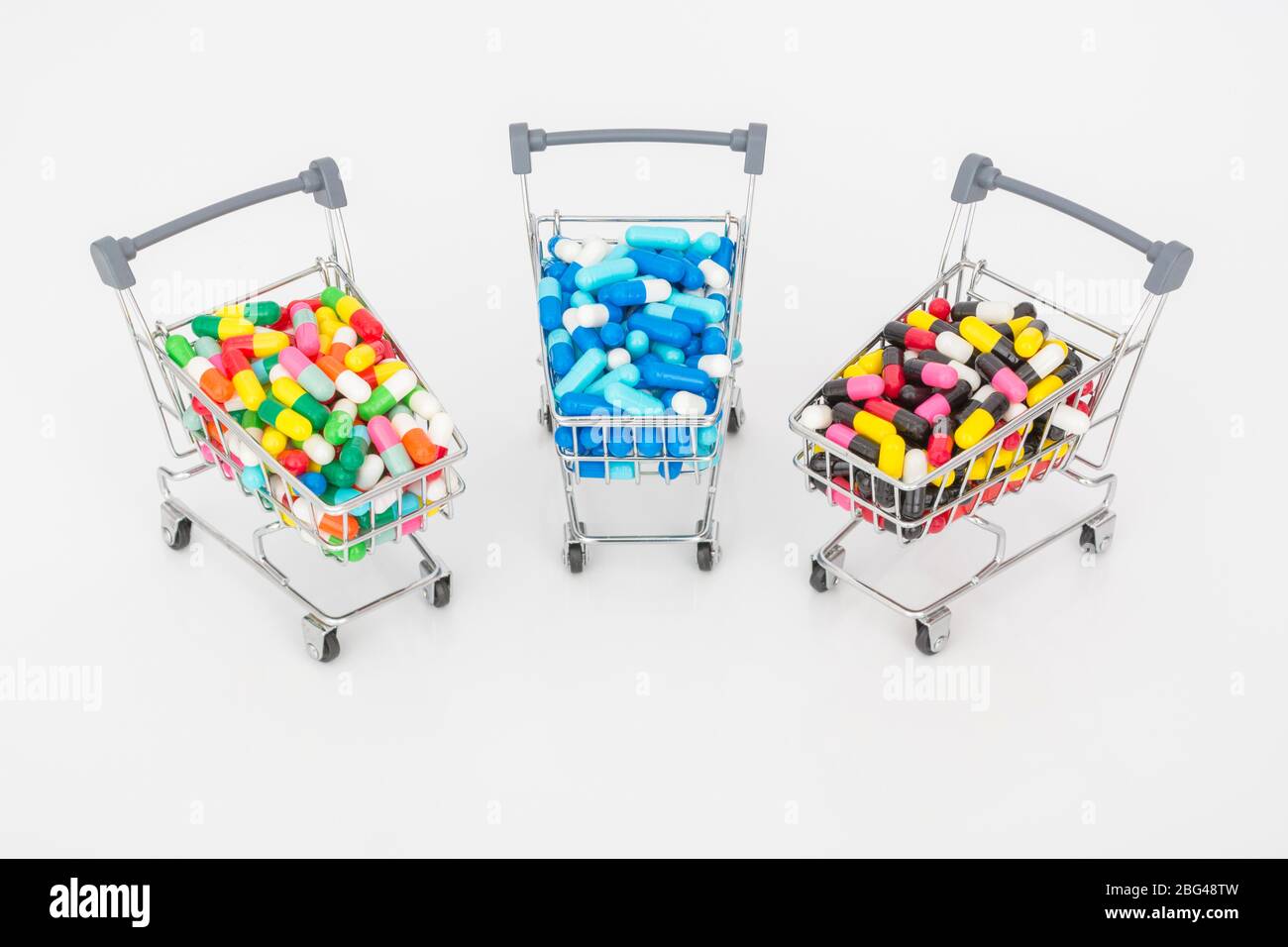 Mini shopping trolley full of colourful pills caplets. Metaphor Big ...