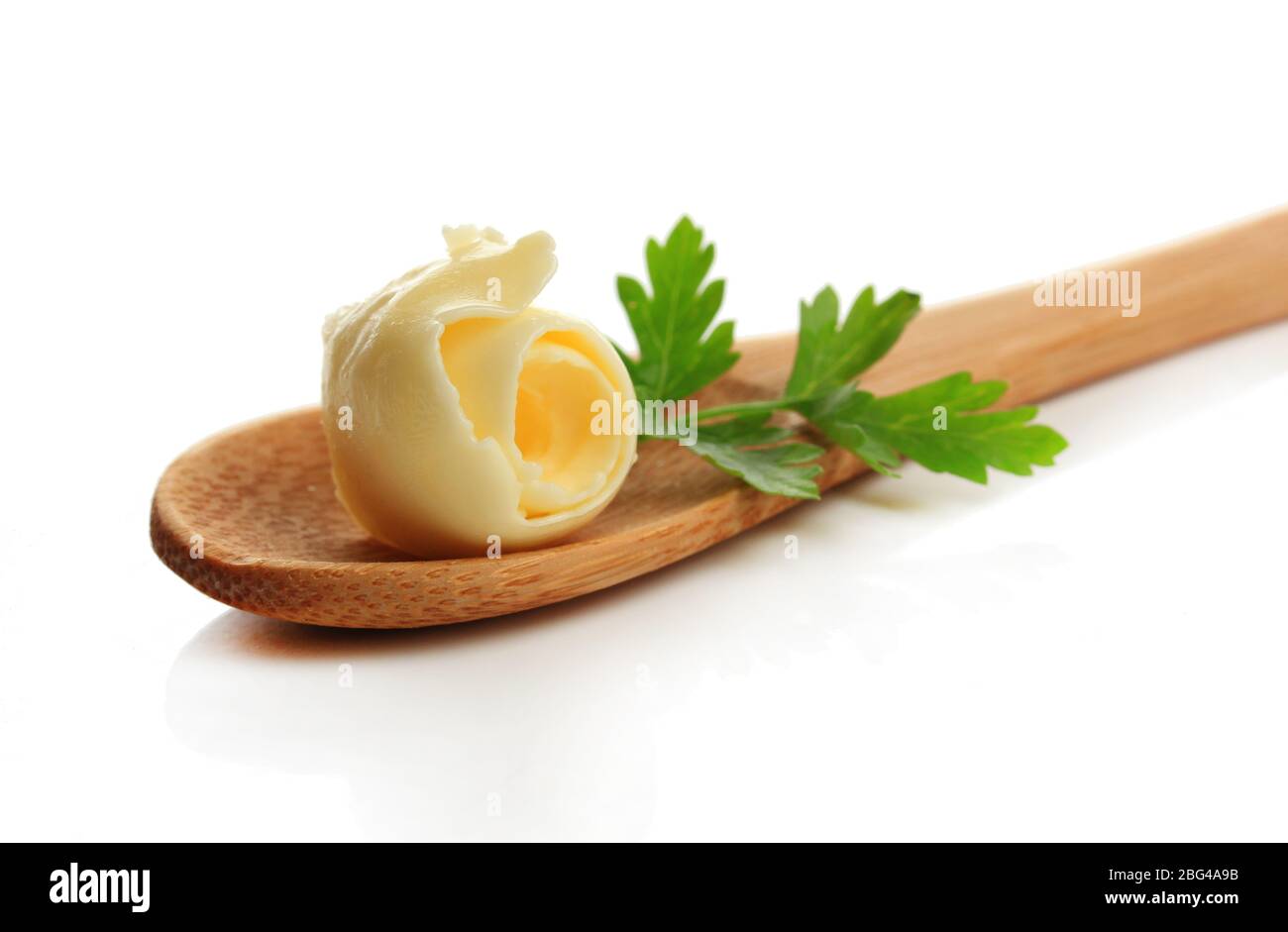 Butter curl on wooden spoon, isolated on white Stock Photo - Alamy