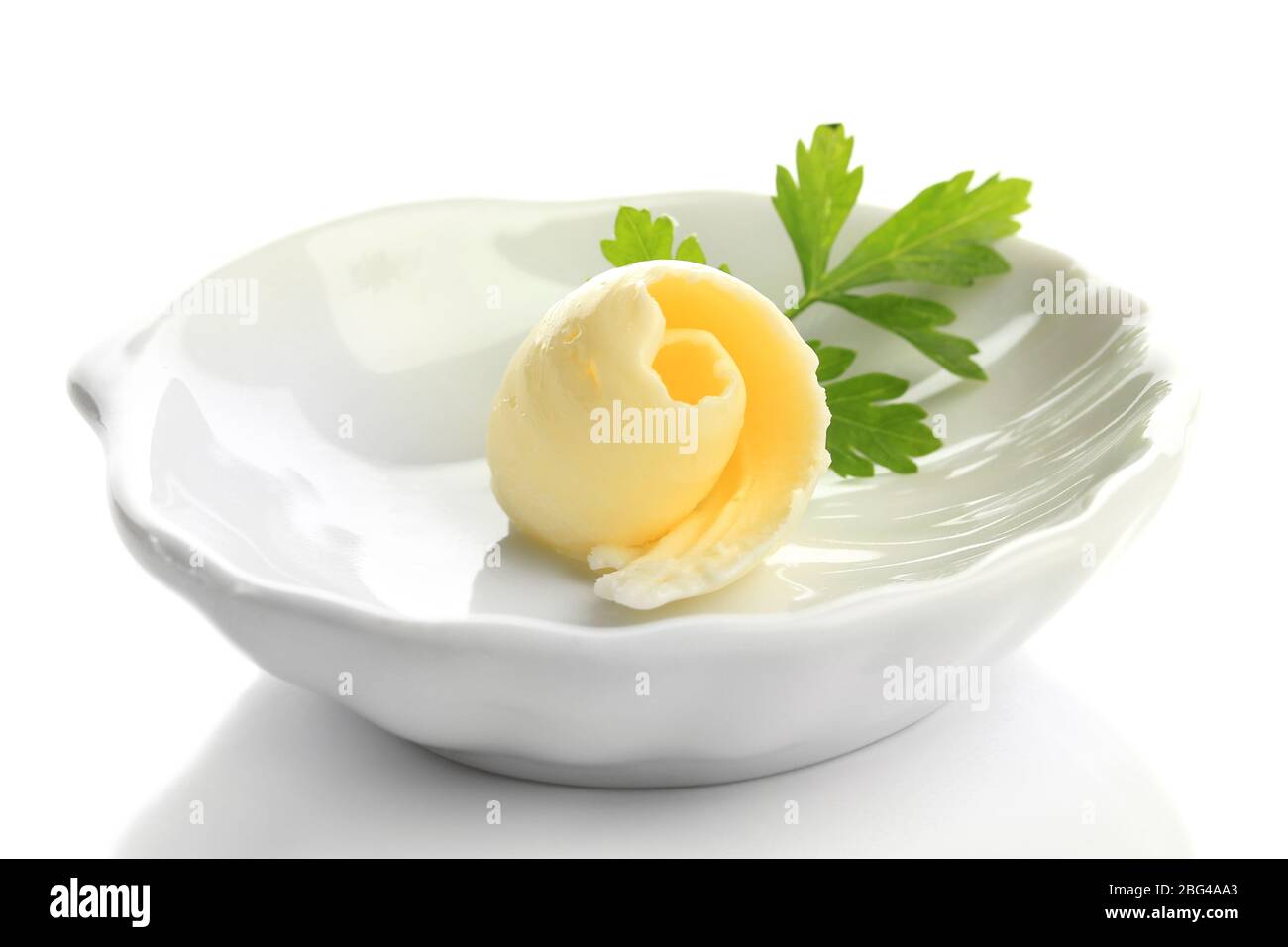 Butter curl on plate, isolated on white Stock Photo - Alamy